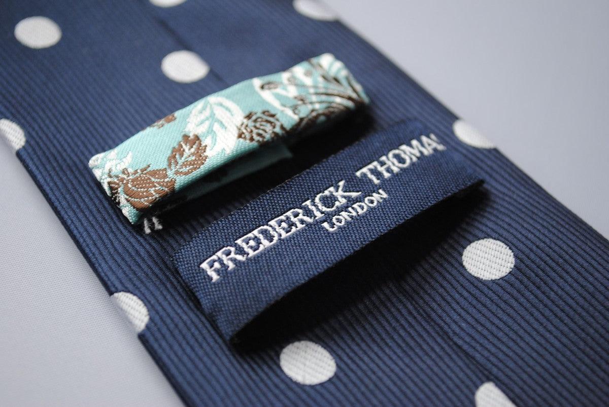 navy blue tie with white spots and signature floral design to rear ...